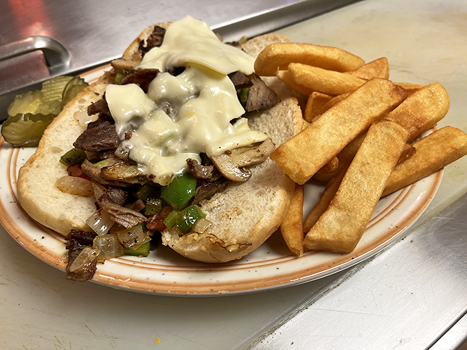 Behold the star attraction: a Philly cheesesteak that would make Philadelphians question their geography. Those golden fries aren't just sides—they're supporting actors deserving their own award.