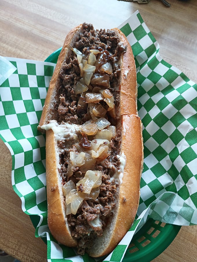 Behold the star of the show: thinly sliced ribeye nestled in a perfect roll, with cheese and onions playing their supporting roles to perfection.