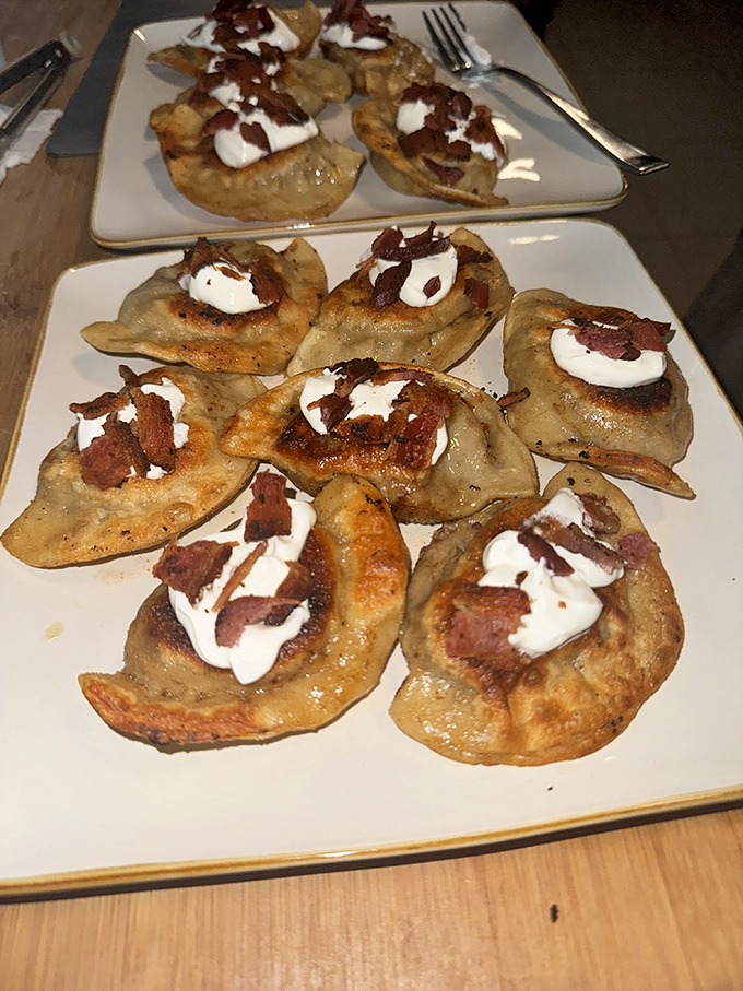 Golden-brown pierogies topped with bacon bits and sour cream—proof that heaven exists and it's shaped like a half-moon dumpling.