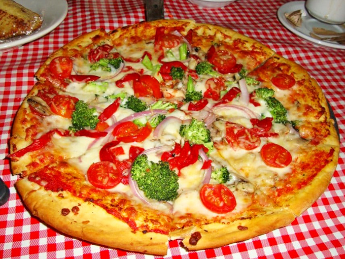 This isn't just pizza—it's architecture. Load-bearing cheese walls support a neighborhood of vegetables in their delicious little community.