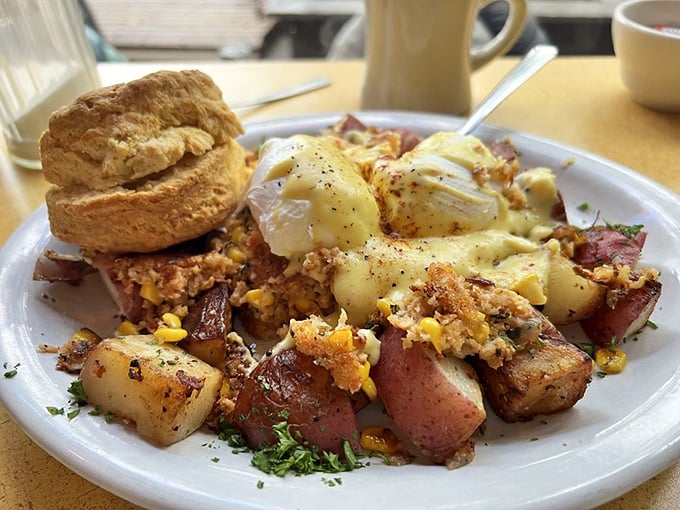 Breakfast alchemy at its finest—poached eggs crowning a mountain of savory hash with a biscuit standing guard. This plate doesn't just feed you; it hugs you.