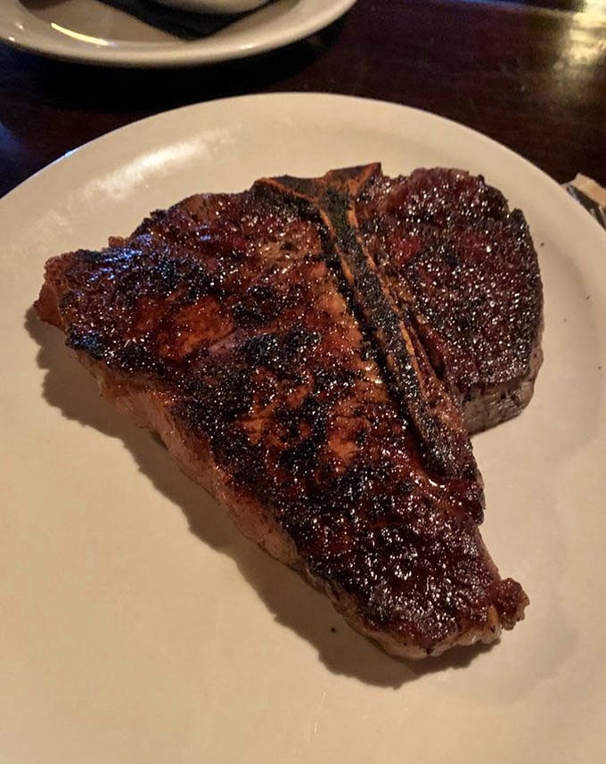 The Porterhouse arrives like a meaty masterpiece—a perfect marriage of strip and tenderloin that makes vegetarians question their life choices.