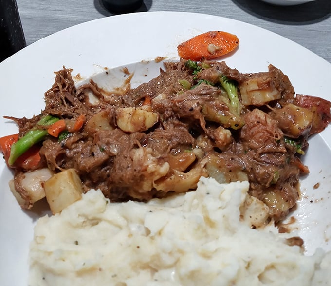 The legendary pot roast in all its glory – fork-tender beef swimming in rich gravy alongside perfectly cooked vegetables. Resistance is futile.