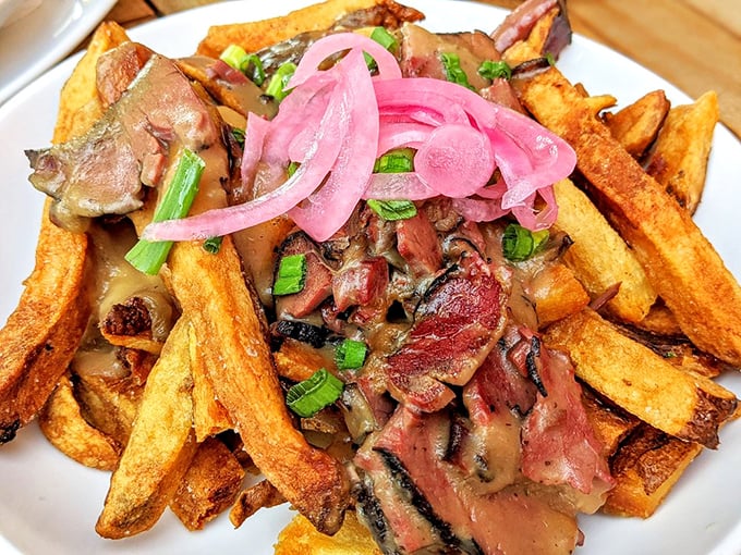 Behold the barbecue poutine—where crispy fries, tender brisket, and pickled red onions create the kind of dish that makes Canadians and Texans equally jealous.