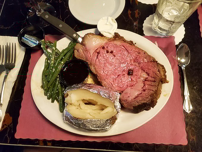 Behold the star attraction: prime rib cooked to rosy perfection, accompanied by green beans and a baked potato. Meat sweats never looked so worth it.