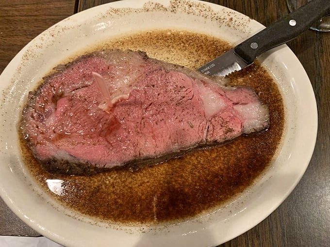 The prime rib arrives like a carnivore's dream, perfectly pink and swimming in a pool of rich au jus that begs to be sopped up with every available carb.