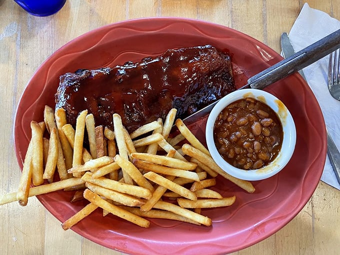 These ribs don't just fall off the bone—they practically leap onto your fork, bringing along their BBQ sauce soulmate and crispy fries for the ride.