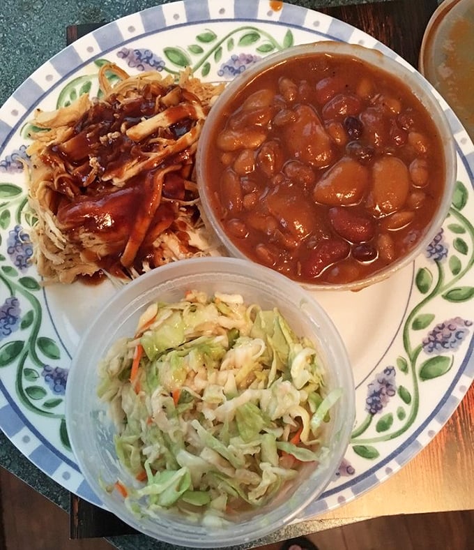 A holy trinity of barbecue goodness—pulled chicken bathed in sauce, hearty baked beans, and coleslaw that adds just the right crunch to cut through the richness.