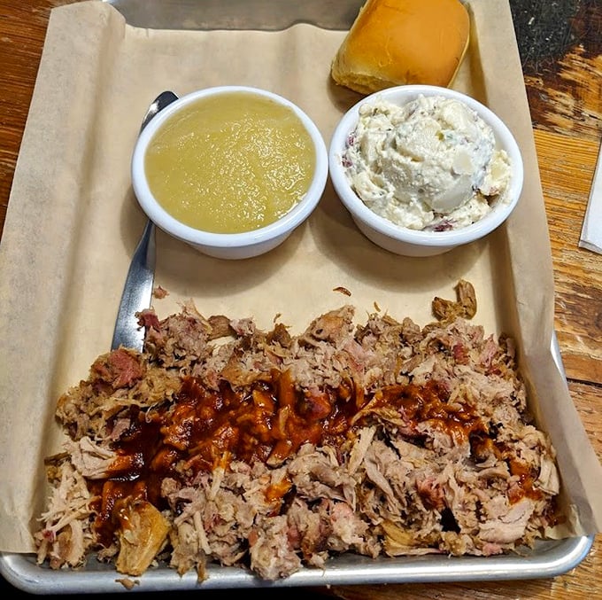 Pulled pork that's been coaxed, not forced, into tender submission. The applesauce and potato salad sides are no mere supporting actors.