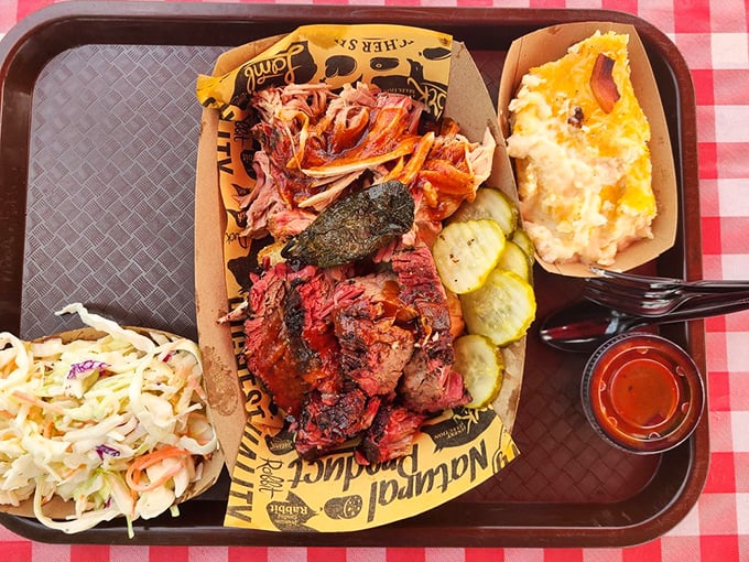 A barbecue tray that hits all the right notes – smoky meat, creamy sides, and those pickles that cut through the richness like a well-timed joke.