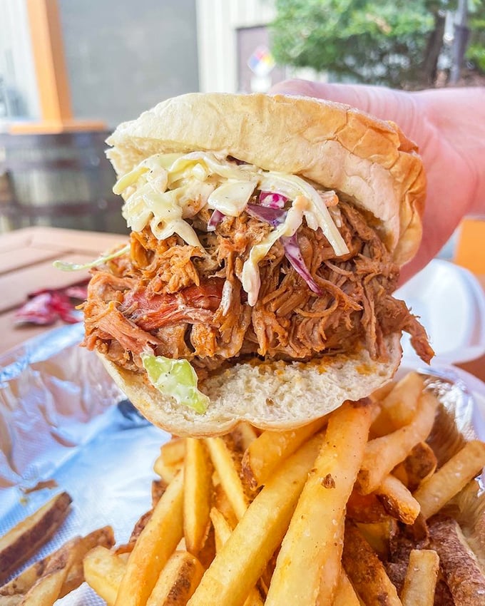 This pulled pork sandwich isn't just a meal—it's an architectural marvel of tender meat, crunchy slaw, and a bun that somehow contains the delicious chaos.