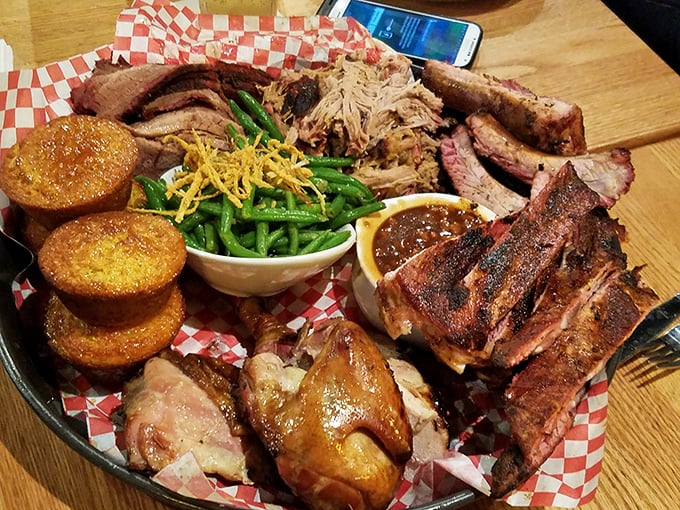 The barbecue platter that makes vegetarians question their life choices—a smoky, meaty landscape dotted with cornbread mountains and green bean valleys.