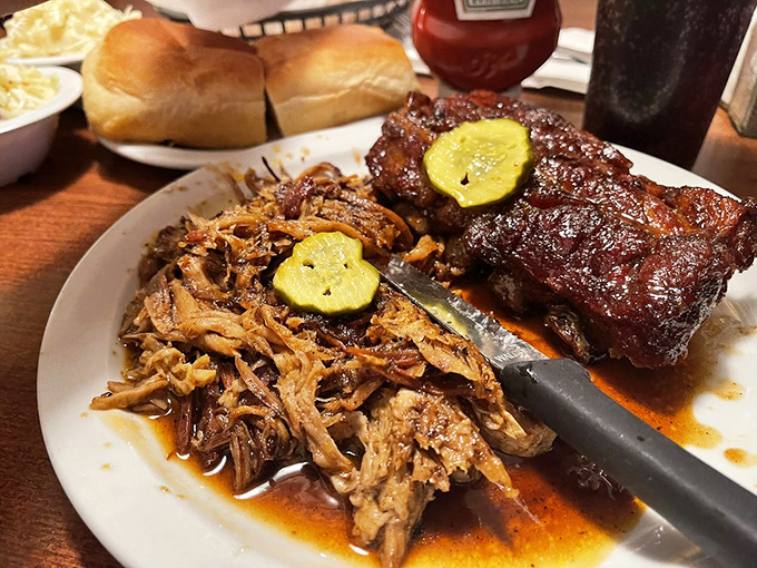 Pulled pork that surrenders at the touch of a fork, paired with ribs that demand your full attention. The pickle slices aren't just garnish—they're essential acid relief.