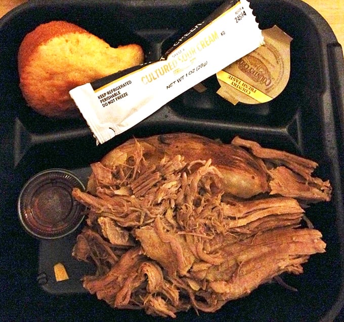 Pulled pork so tender it practically surrenders to your fork. That cornbread muffin isn't just a side—it's the perfect tool for sopping up every last drop of flavor.