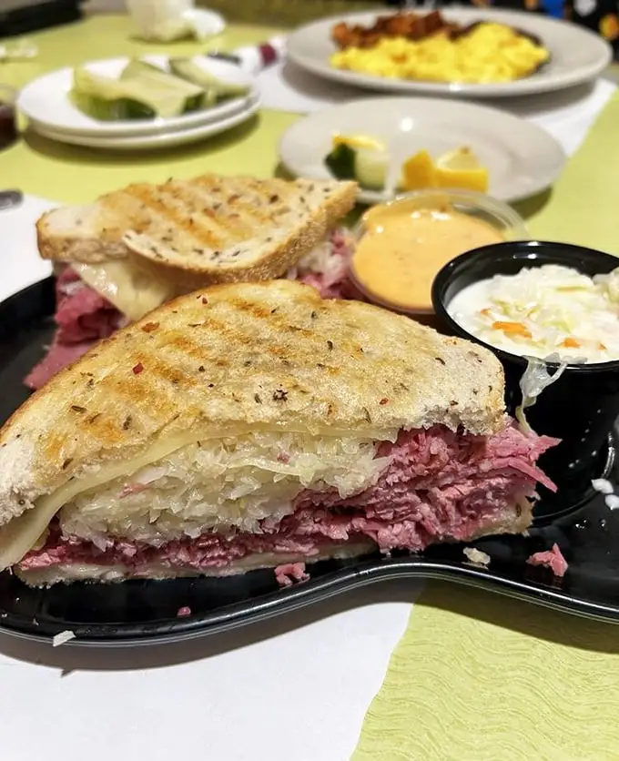 This isn't just a Reuben—it's architecture. Layers of corned beef and sauerkraut create a sandwich skyscraper that requires both hands and a strategy.