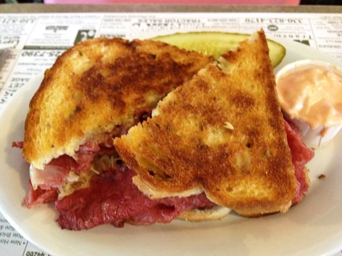 That, my friends, is what sandwich dreams are made of – a perfectly grilled Reuben with corned beef stacked high enough to make your cardiologist wince.