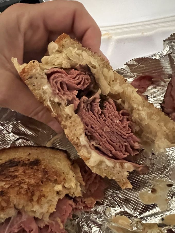 Behold the Reuben in its natural habitat – perfectly grilled rye embracing a mountain of corned beef and sauerkraut. This isn't a sandwich; it's a religious experience.