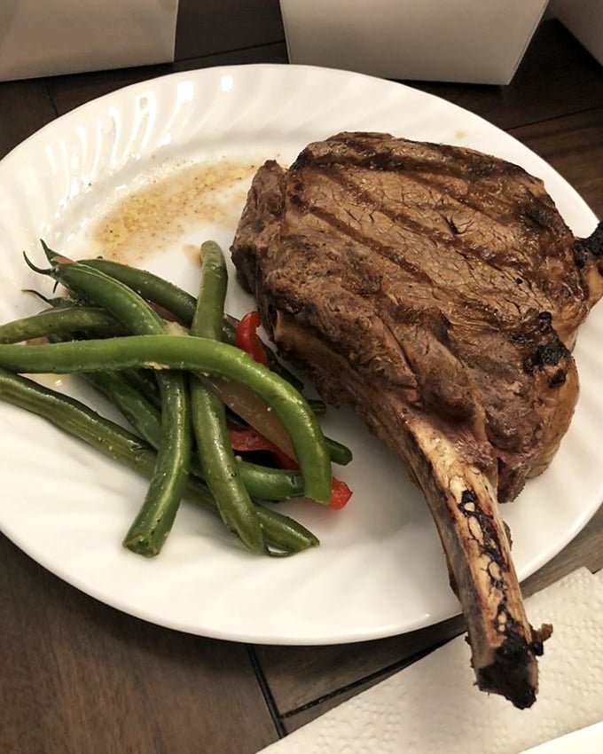 This bone-in ribeye isn't just dinner—it's a religious experience with green beans. The perfect char tells you someone in the kitchen really cares.