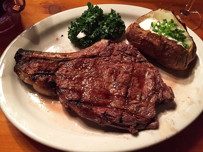 Behold the ribeye in its natural habitat—perfectly charred, gloriously juicy, and flanked by its loyal companions: a loaded baked potato and token green vegetable.