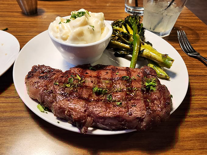 Behold the ribeye in its natural habitat—perfectly seared, resting beside creamy mashed potatoes and grilled asparagus. Poetry on a plate.