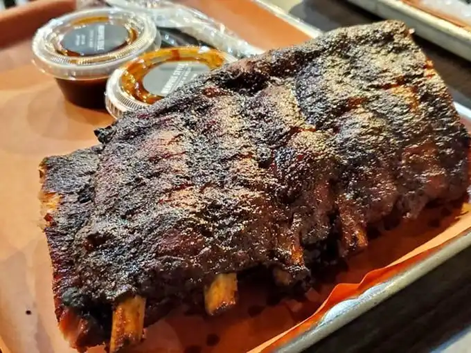 Behold the ribs—bark so perfect it should be in a museum. That smoke ring isn't just pink; it's a halo of flavor.