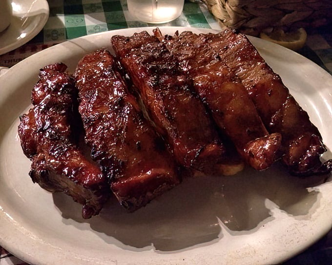 These ribs glisten like mahogany furniture you actually want to eat – and trust me, you absolutely do.