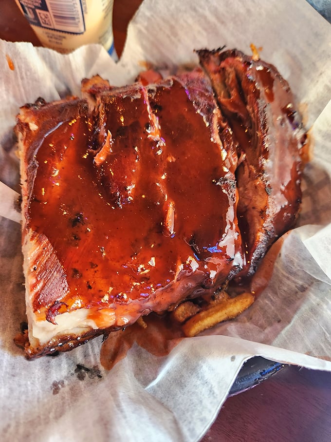 Behold the star of the show: ribs glistening with that signature sauce. That beautiful smoke ring isn't just for show—it's a pink badge of barbecue honor.