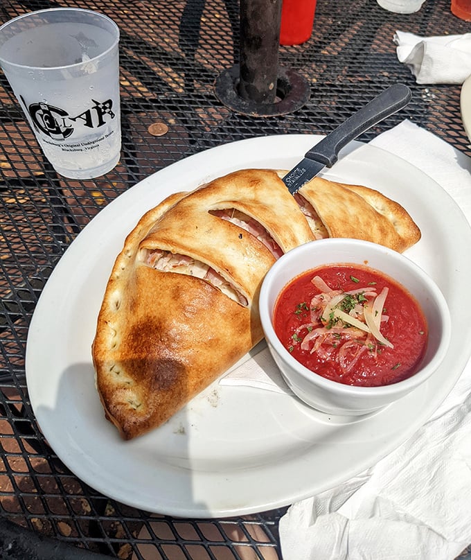 The calzone that launched a thousand cravings – golden-brown perfection with marinara so vibrant it deserves its own Instagram account.