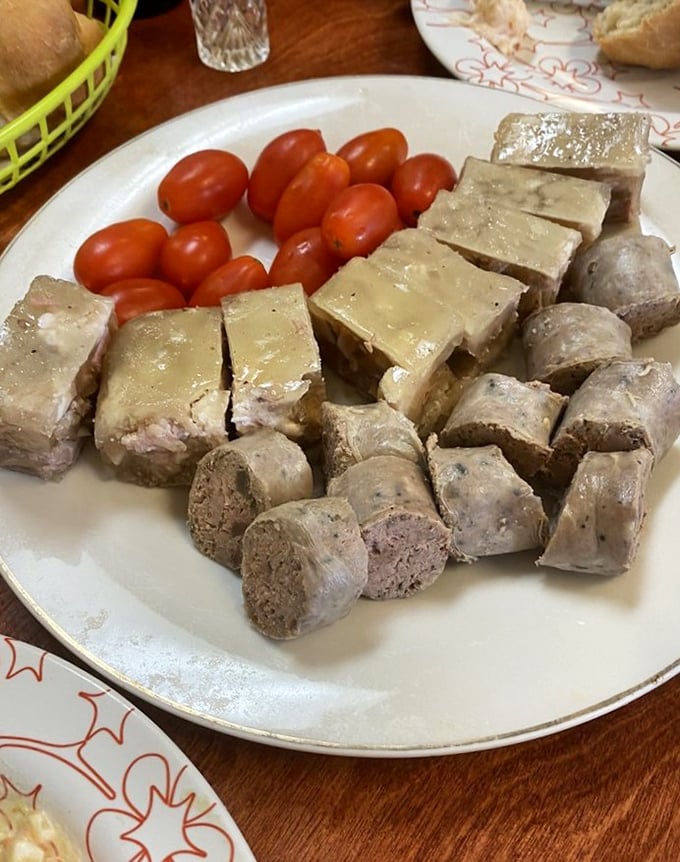 Behold the star attraction: Romanian sausage and headcheese with cherry tomatoes. This plate isn't just food—it's cultural heritage served with pride.