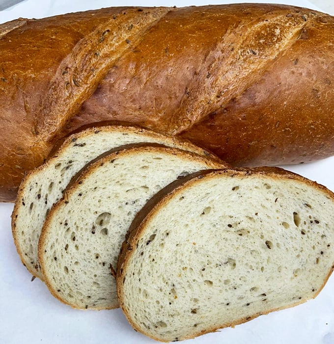 This isn't just bread; it's a caraway-studded masterpiece with a crust that snaps and an interior that yields – the foundation of sandwich greatness.