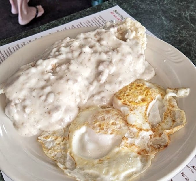 Behold the star attraction: sausage gravy that doesn't just cover the biscuit—it embraces it in a peppery, creamy bear hug.