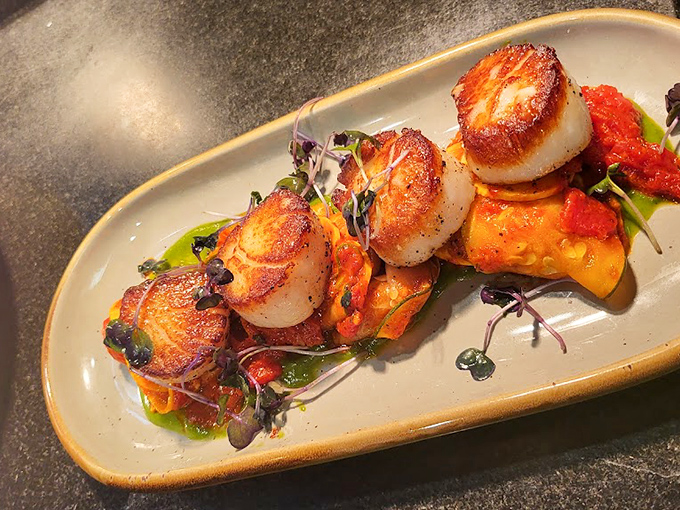 These perfectly seared scallops aren't just cooked – they're transformed into buttery medallions of oceanic bliss on a colorful canvas.