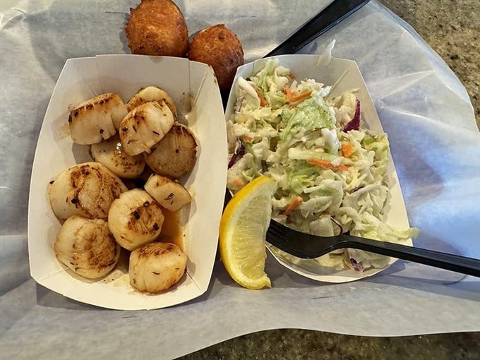 These scallops aren't just seared, they're kissed by fire until golden, then served with hush puppies that could make a southerner weep.