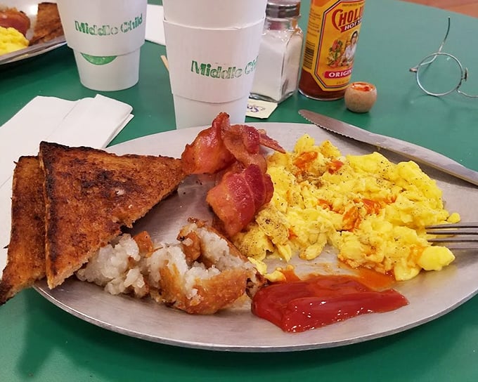 Breakfast nirvana on a plate: golden scrambled eggs that look like they've been whispered into perfection, crispy toast, and bacon that's achieved that magical crisp-yet-tender balance.