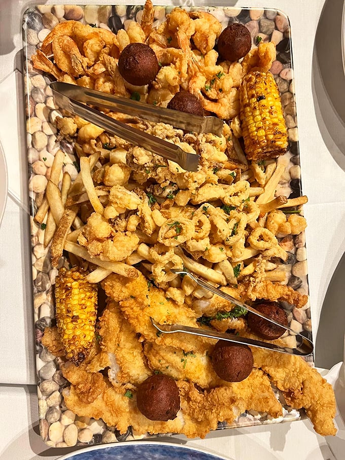 This seafood platter isn't just dinner—it's an edible work of art featuring golden-fried treasures from the deep, complete with hush puppies and grilled corn.