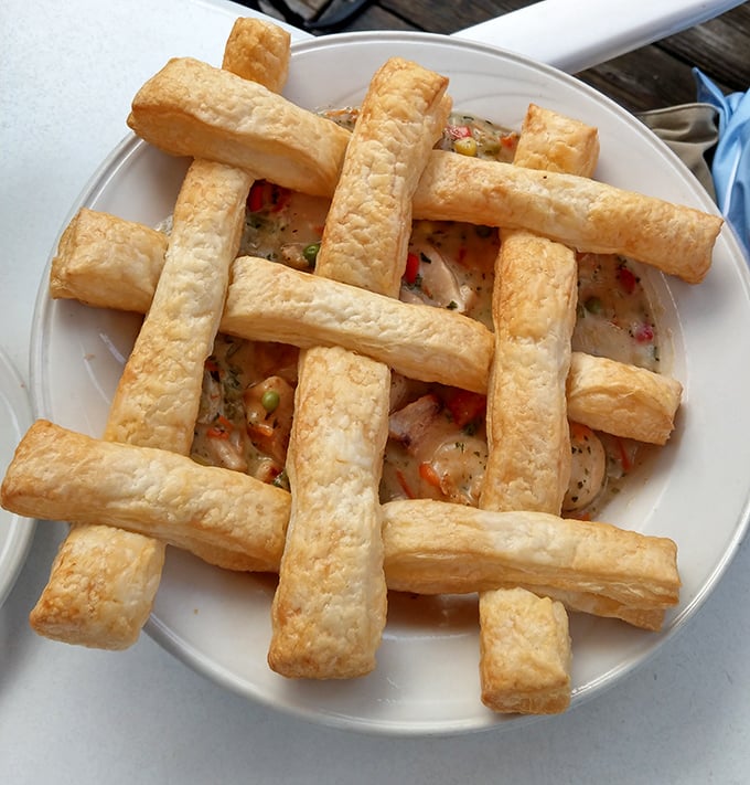 The legendary seafood pot pie arrives like edible architecture – golden pastry lattice revealing a creamy ocean of treasures hiding beneath.