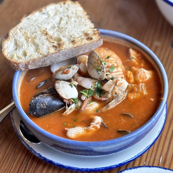 A seafood stew so hearty it could make Neptune himself swim to shore. Those clams aren't just swimming—they're doing synchronized diving. 