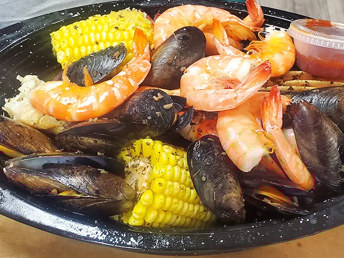 A steaming pot of oceanic treasures—where plump shrimp, sweet corn, and briny mussels commingle in a seasoned broth that could make Neptune himself weep with joy.