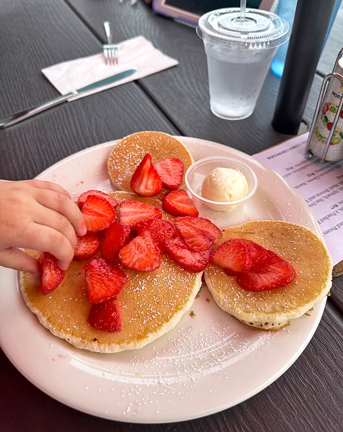 These golden pancakes topped with fresh strawberries aren't just breakfast – they're edible sunshine that makes you forget what day of the week it is.