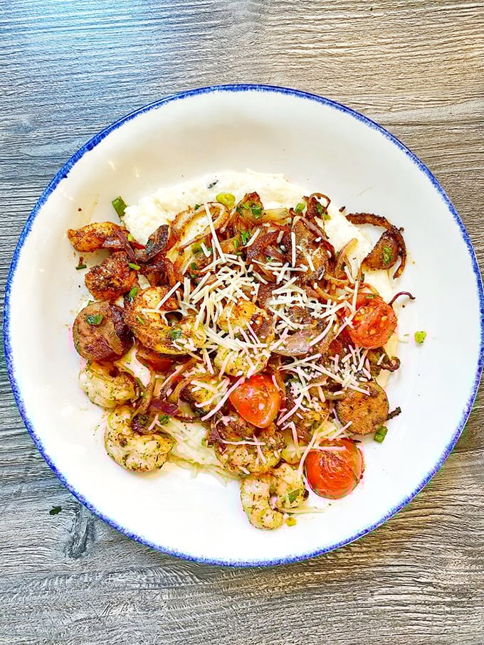 Blackened shrimp dancing atop creamy grits with roasted tomatoes—a bowl that proves South Carolina's seafood deserves every bit of its legendary status.
