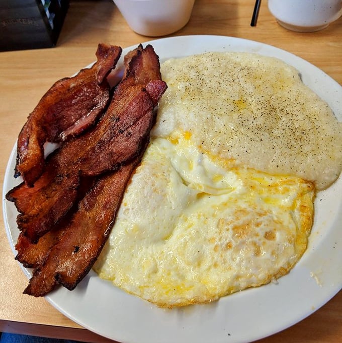 Crispy bacon, sunny-side-up eggs, and creamy grits – the holy trinity of Southern breakfast executed to perfection.