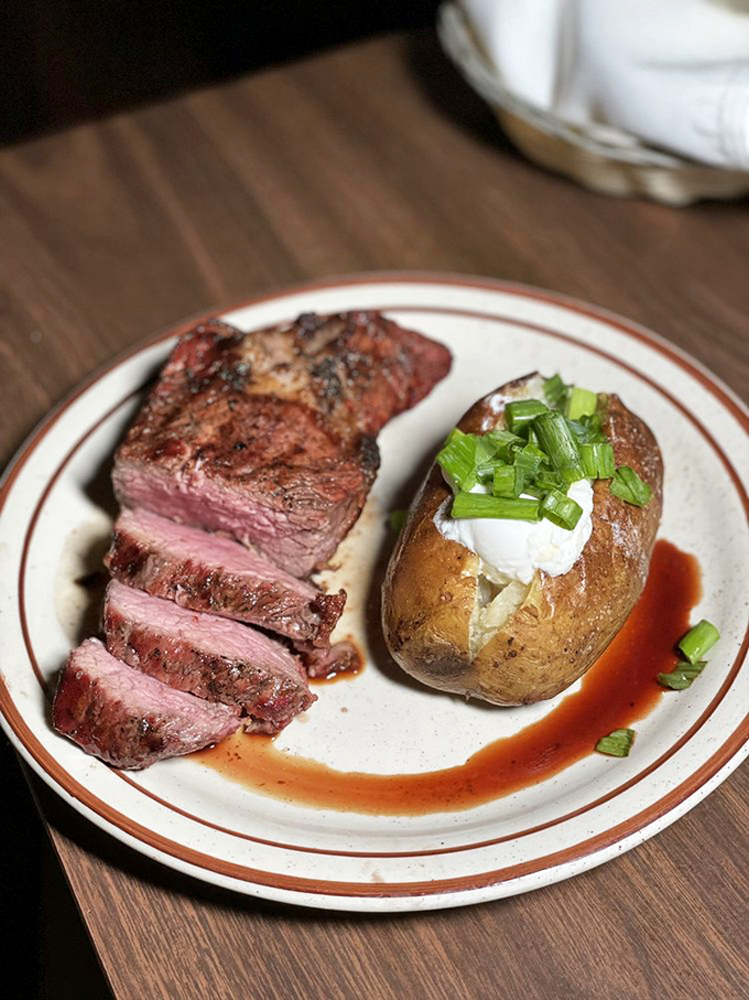 The star of the show: a perfectly medium-rare steak with a baked potato standing by. This isn't just dinner—it's a life event.