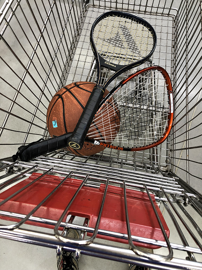 Tennis rackets and basketballs await their second act in a shopping cart – sporting goods that let you try new hobbies without the first-timer price tag.