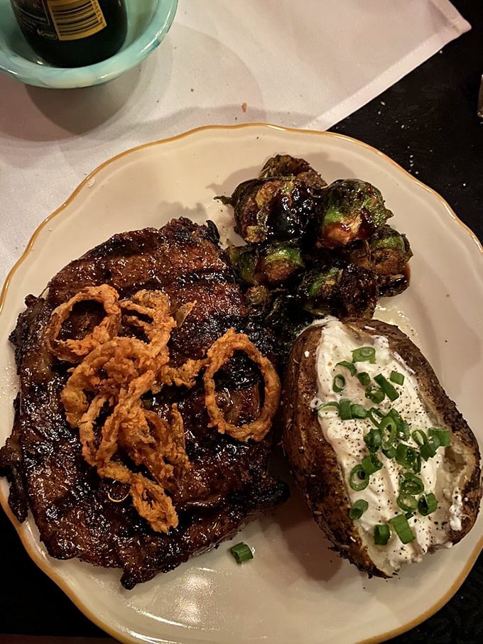 This isn't just a steak—it's a masterpiece of marbling topped with crispy onions that would make even vegetarians pause for a moment of respect.