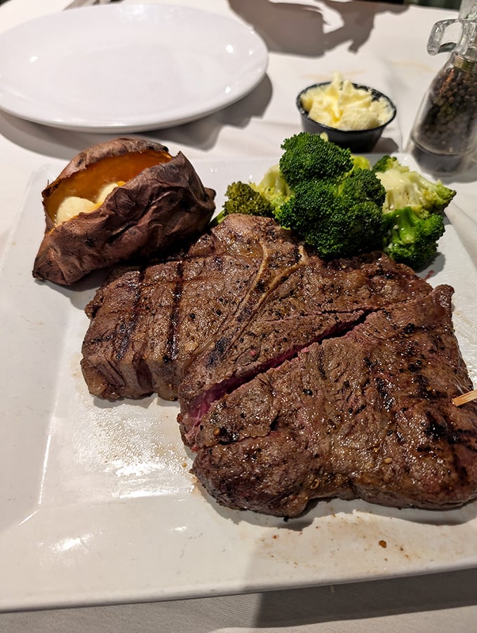 Behold the steak that launched a thousand food dreams—perfectly seared, properly rested, and accompanied by a baked potato that's practically begging to be devoured.