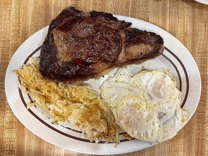 Behold the star attraction: a perfectly seared steak alongside sunny eggs and crispy hash browns—the holy trinity of diner breakfasts.