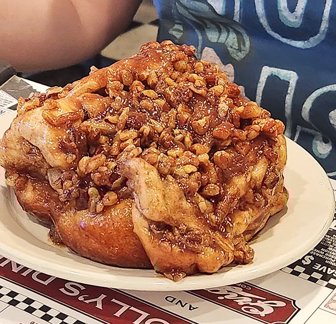 This sticky bun isn't just breakfast—it's an architectural marvel of dough, cinnamon, and enough nuts to make a squirrel weep with joy.