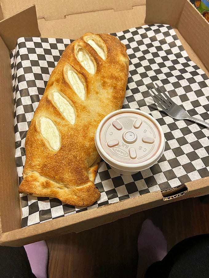 Golden-brown perfection! This stromboli isn't just food; it's edible architecture with a side of marinara for dipping.