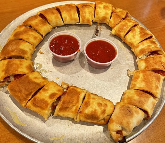 Behold the legendary stromboli—a golden-brown circle of joy with marinara dipping cups standing by for their supporting role.