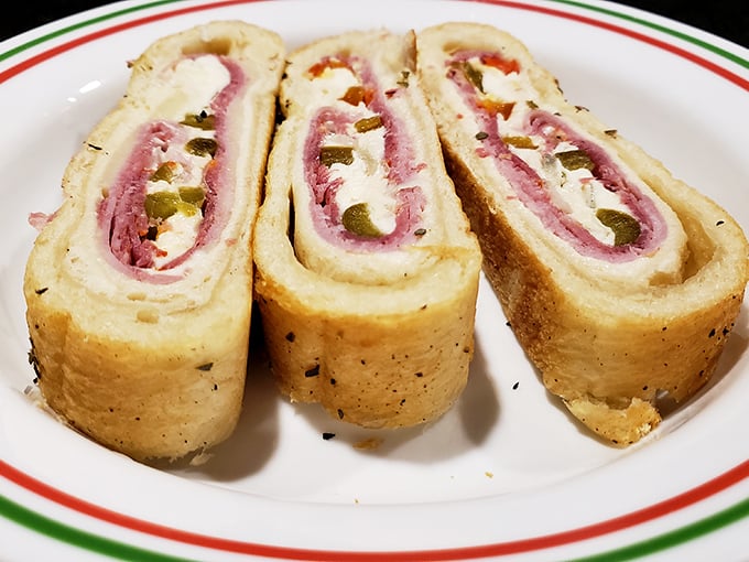 Behold the stromboli in all its glory – a perfect spiral of dough, meat, cheese, and peppers that would make even the most stoic Italian grandmother weep with joy.